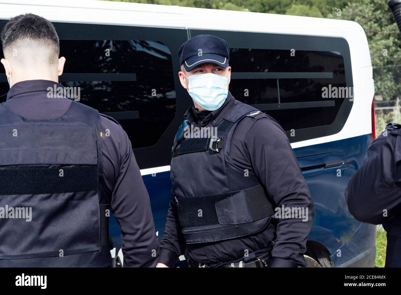 Anonymous policeman in sterile mask and uniform standing near crop ...