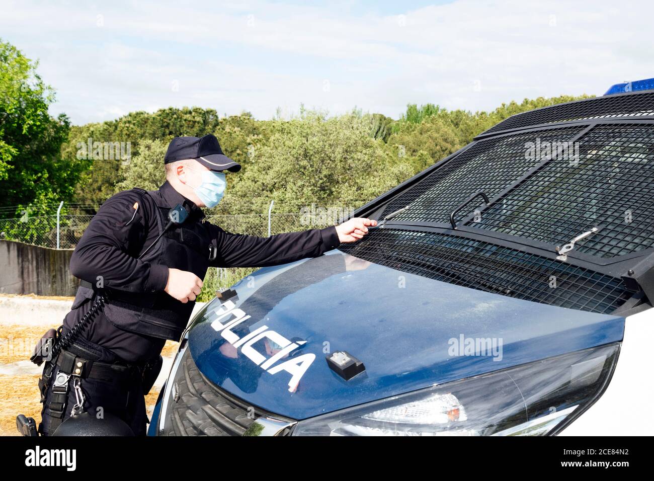 Side view of anonymous police officer in sterile mask and uniform with ...