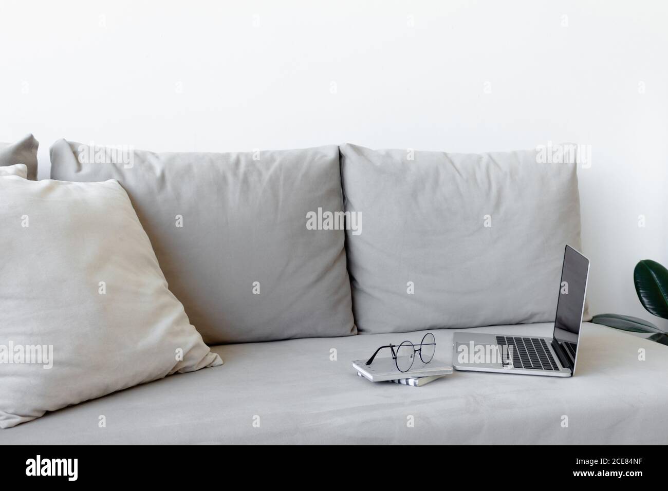 Laptop, glasses, notepads on a gray sofa. Home office concept Stock ...