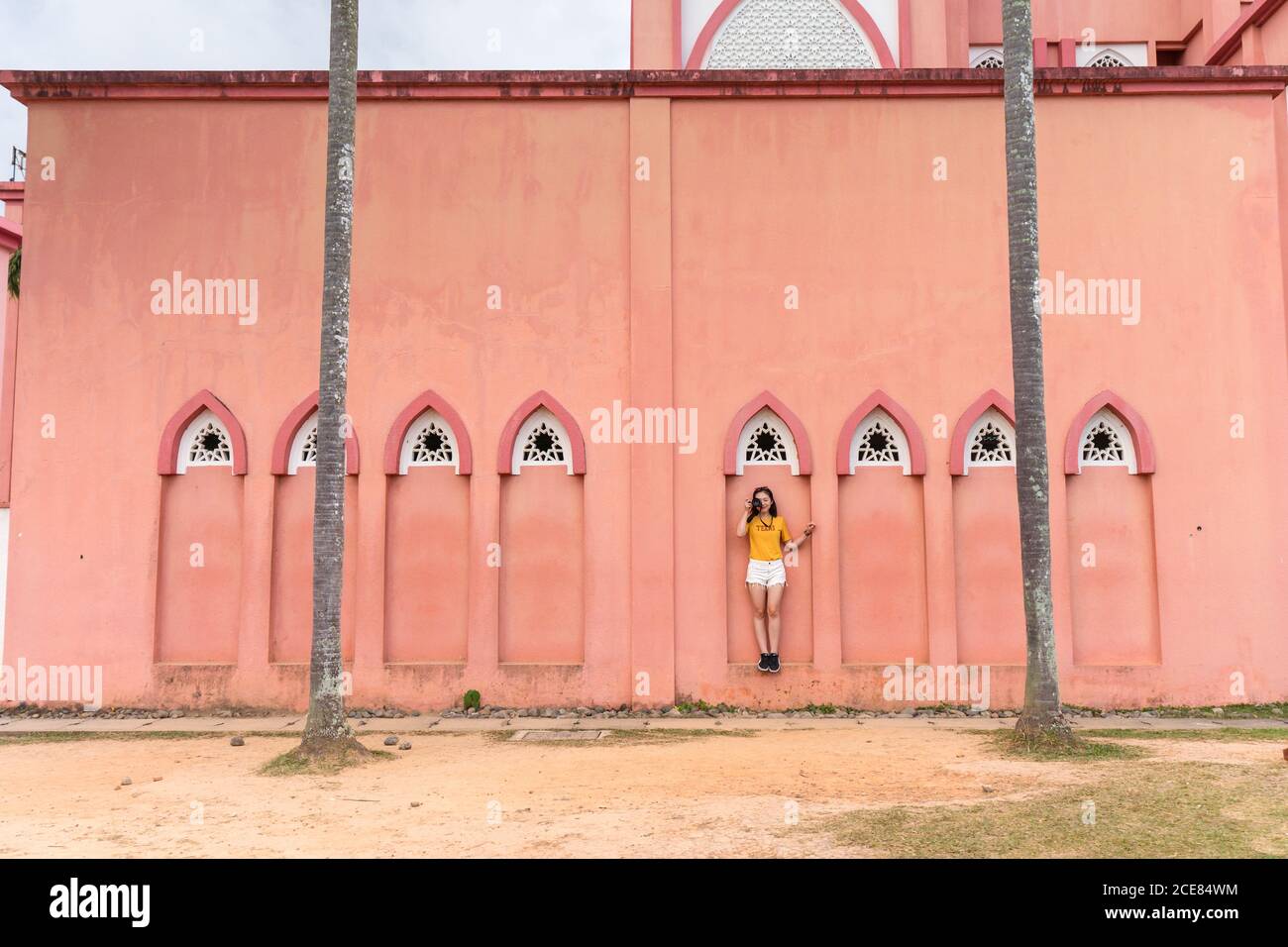 Female tourist in summer wear standing in arch of UMS Mosque with photo ...