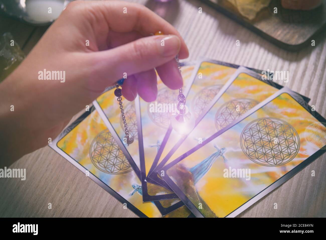Tarot cards dowsing tool in hand and crystals as a concept of psychic ...