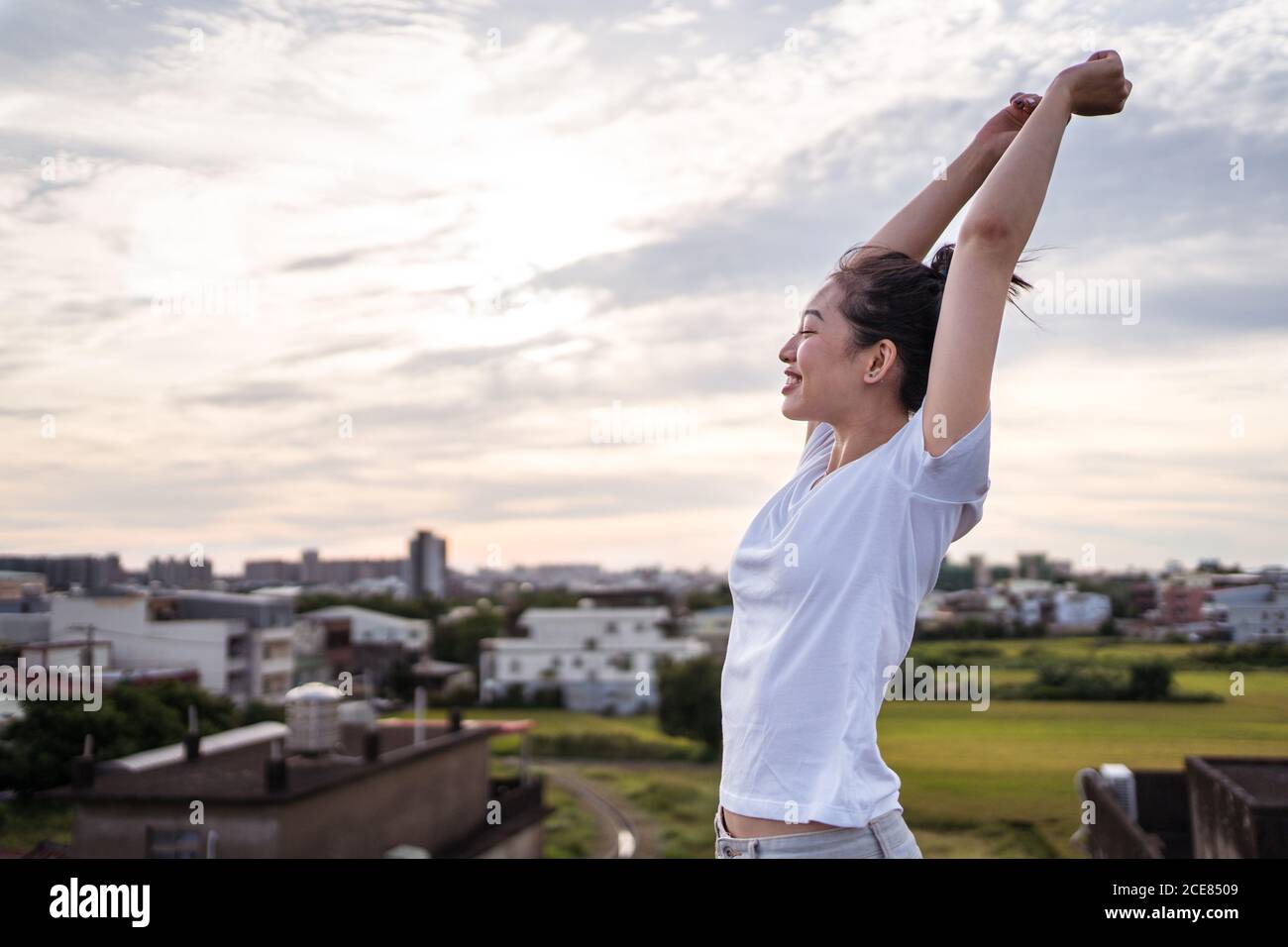 Side view of delighted ethnic female with raised arms smiling and ...
