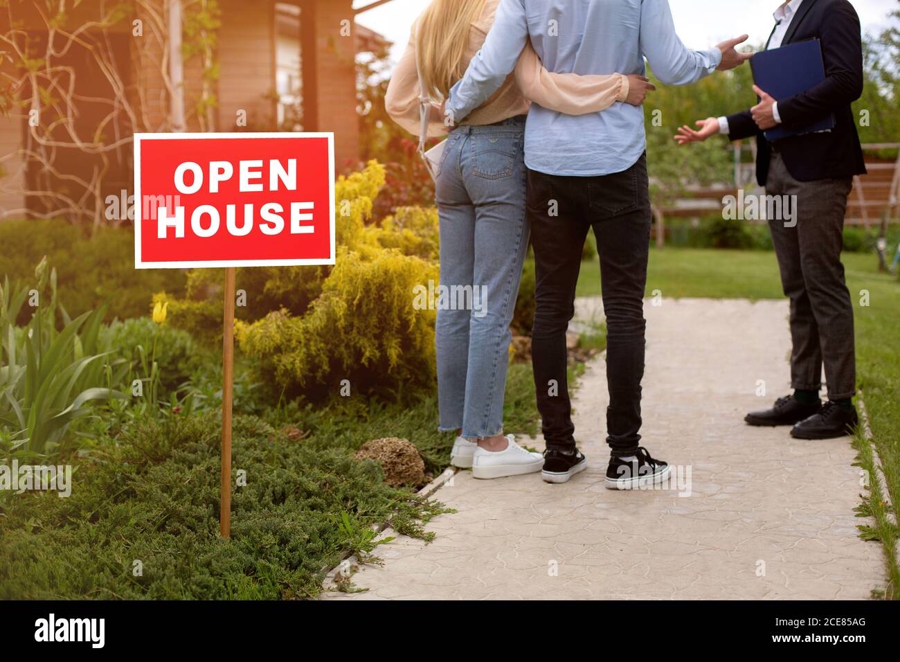 OPEN HOUSE sign and realtor showing potential buyers property for sale ...