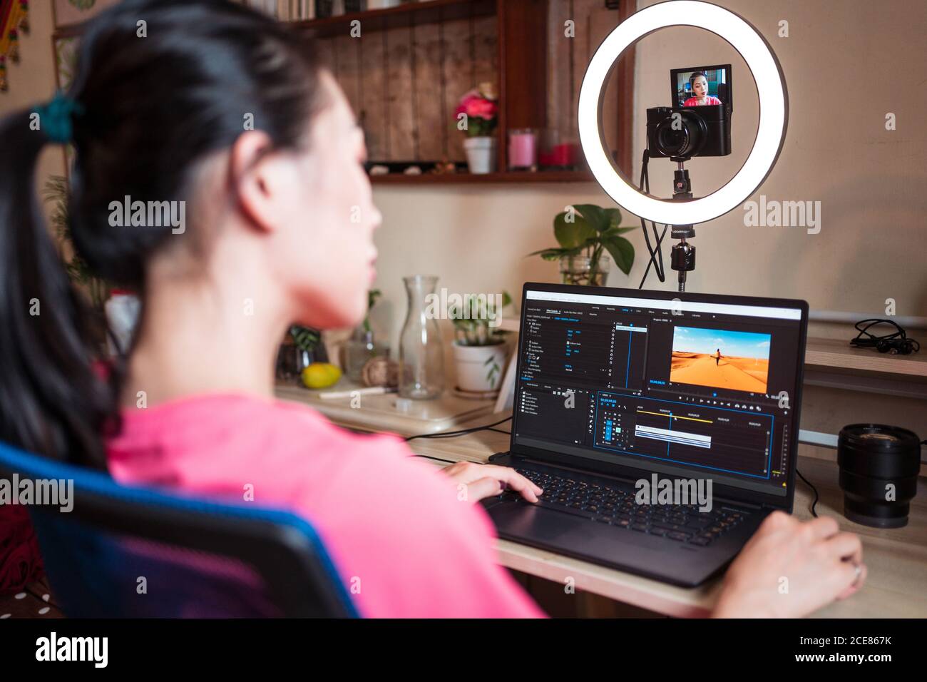 Young Asian female beauty influencer with bright makeup waving hand and ...