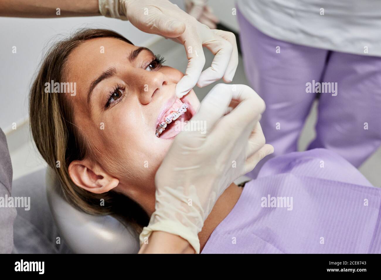 From above of faceless dental doctor checking teeth of female client ...