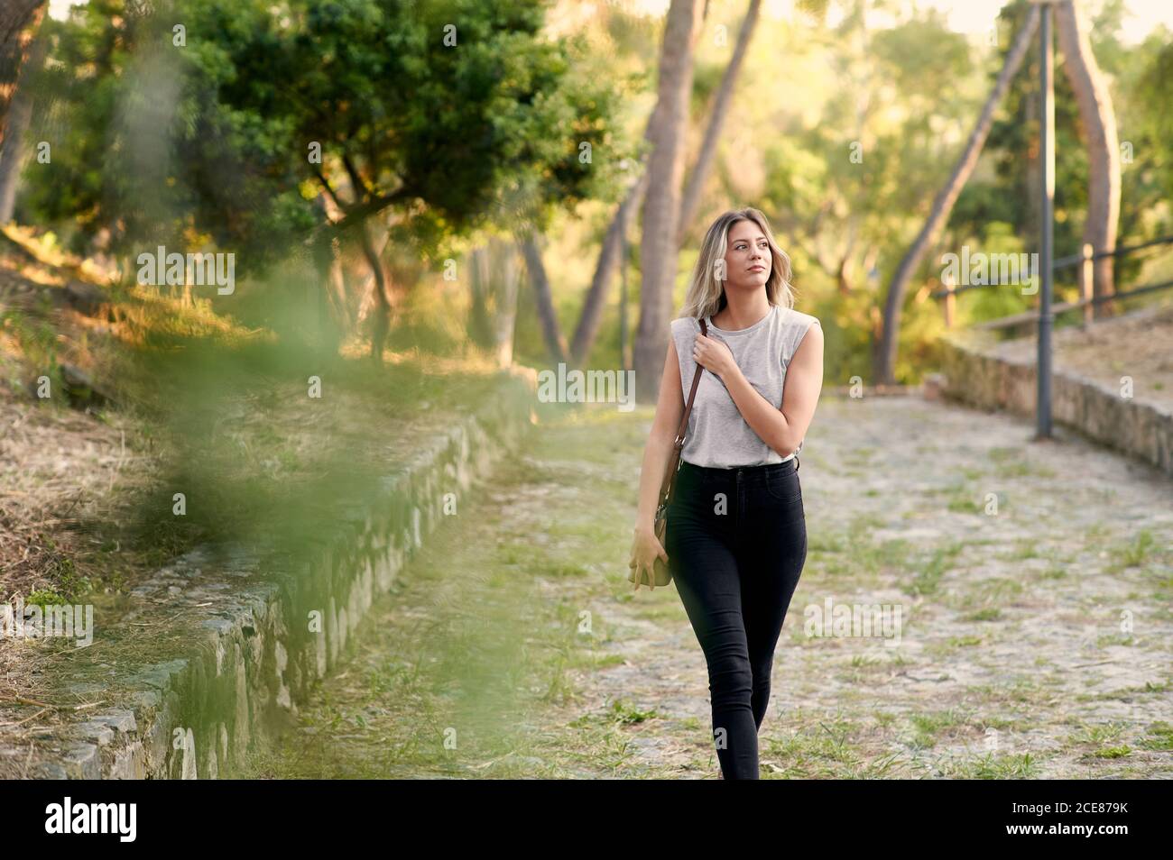 Calm confident young female in casual outfit enjoying sunny summer day ...