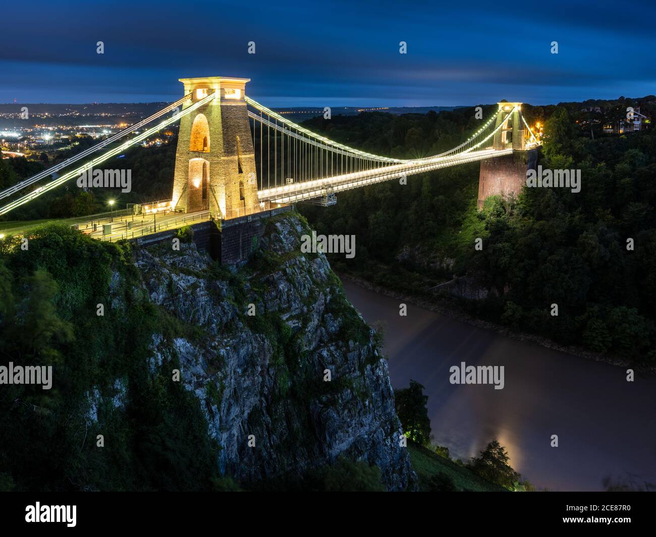The iconic Clifton Suspension Bridge is lit at dusk over the River Avon ...