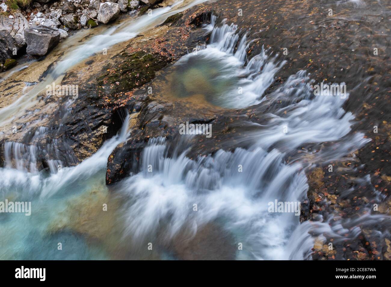Picturesque scenery of rapid river with wide waterfall and rocky pool ...