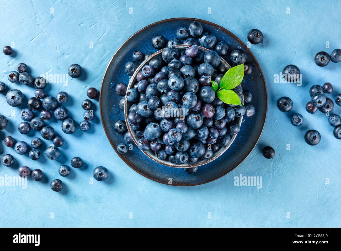 Fresh blueberries with green leaves, shot from above Stock Photo - Alamy