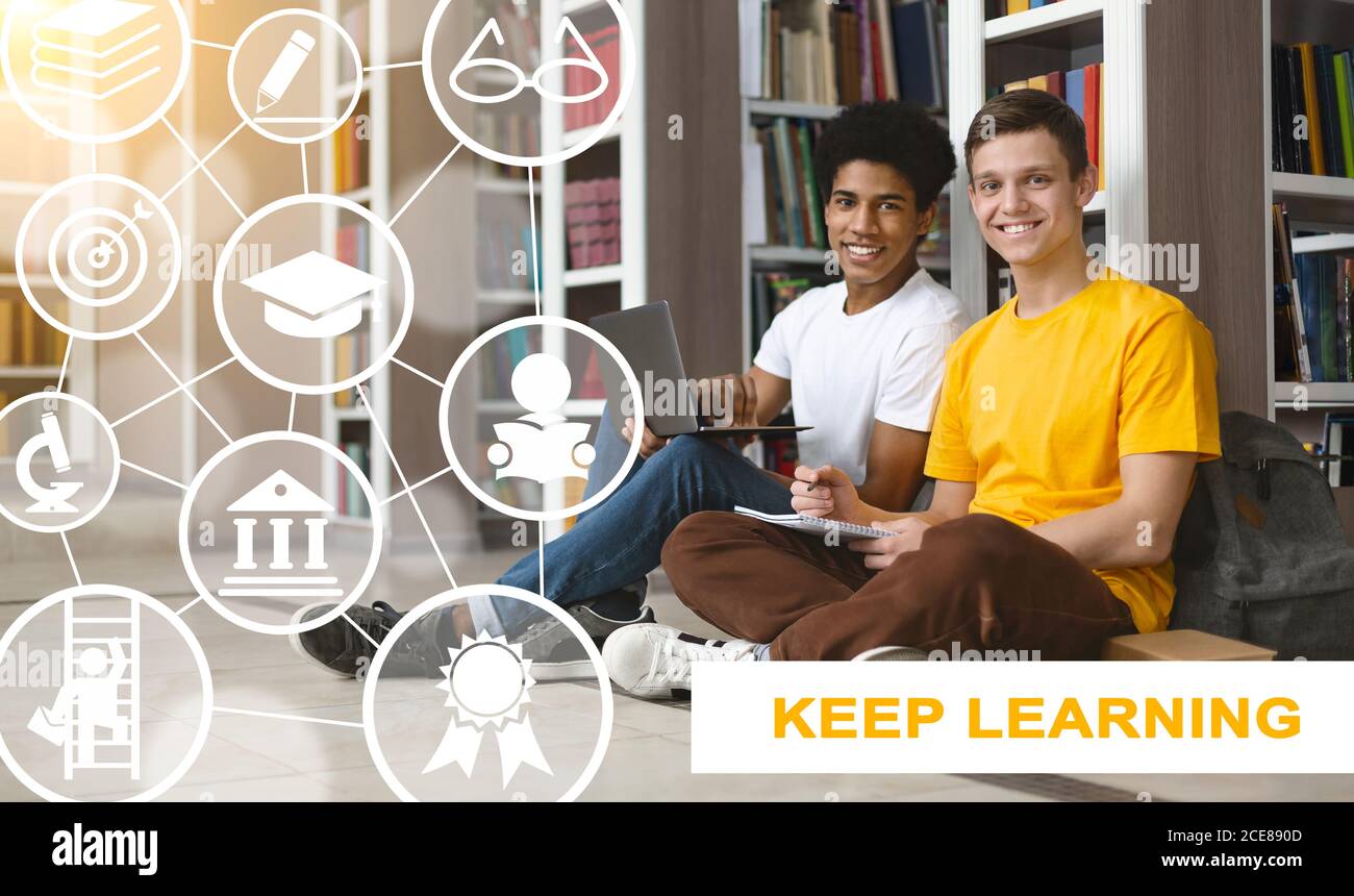 Two Diverse Students Studying Using Computers Sitting In Library ...