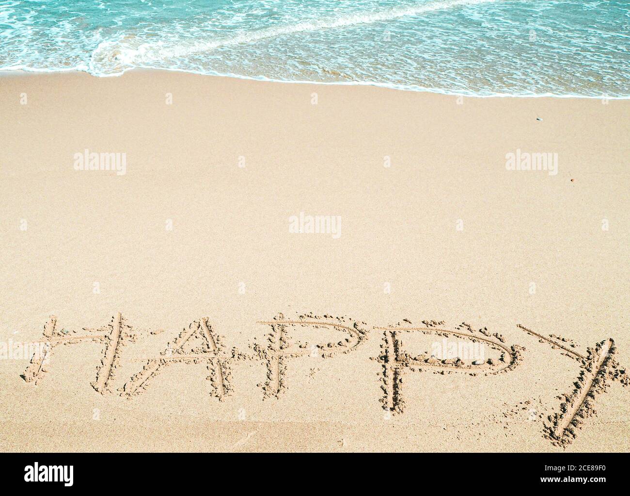 Happy words on the beach. Happy handwritten words on sand Stock Photo ...