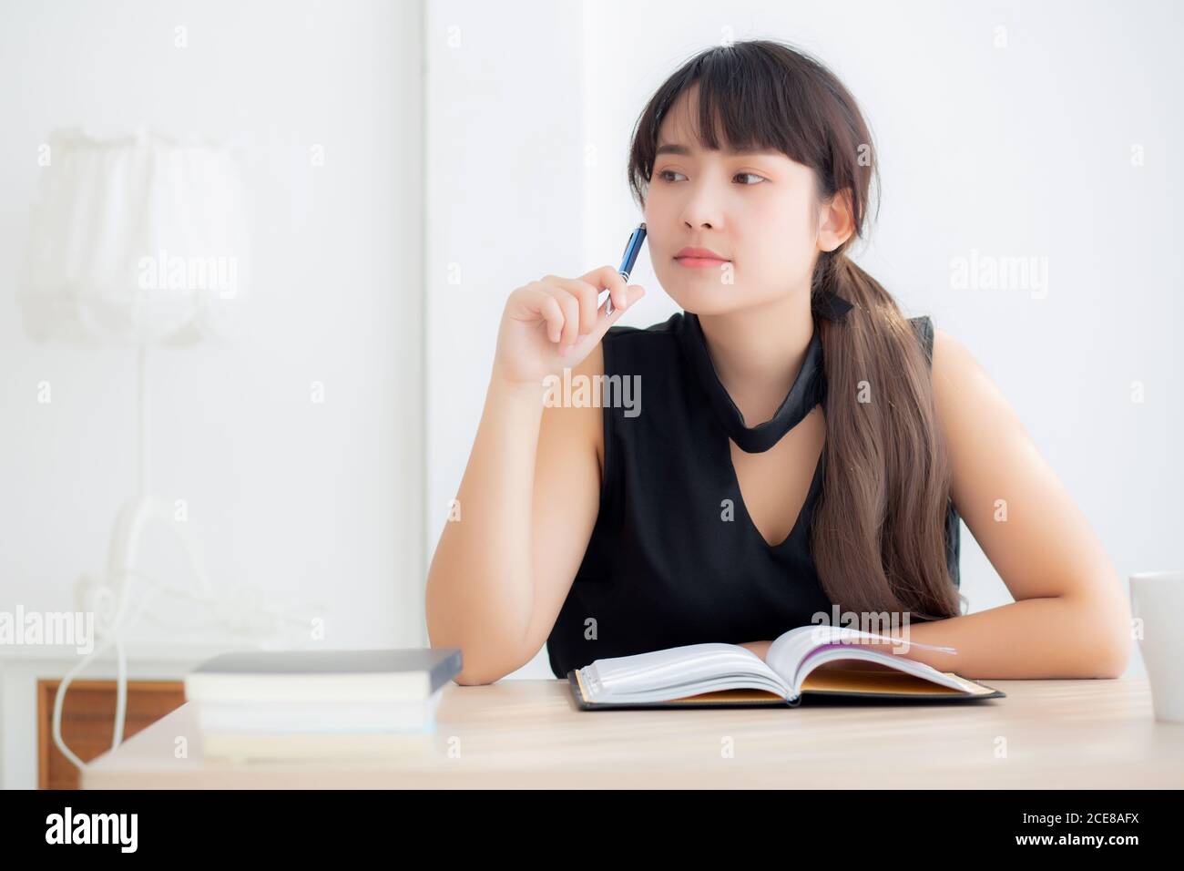 Beautiful asian woman writer smiling thinking idea and writing on ...