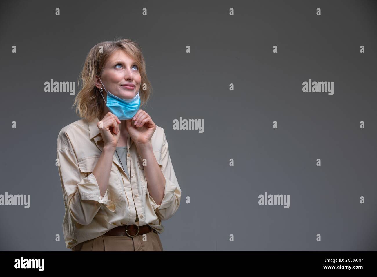 Blond woman take off her surgical mask Stock Photo - Alamy