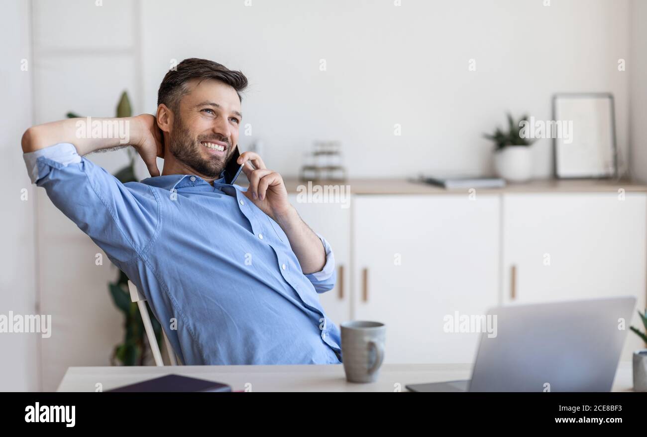 Pleasant Call. Handsome man office worker talking on cellphone at ...
