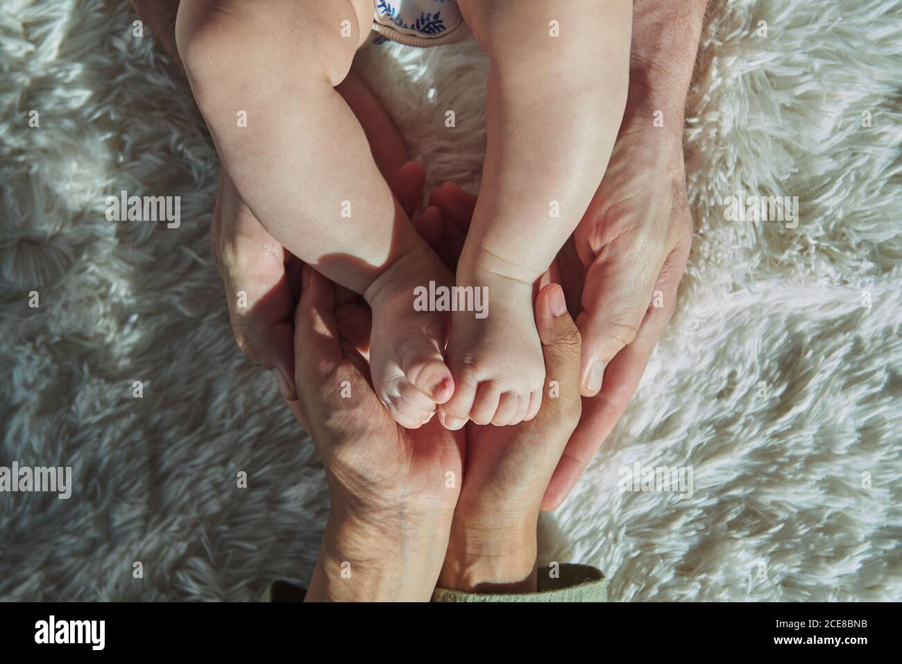 Baby hands holding feet hi-res stock photography and images - Alamy