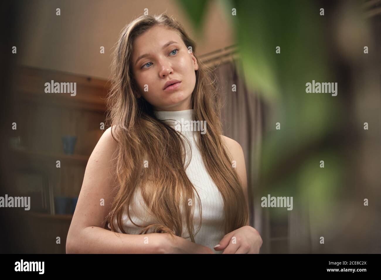 Thoughtful young slim lady with long hair in mini skirt and top ...