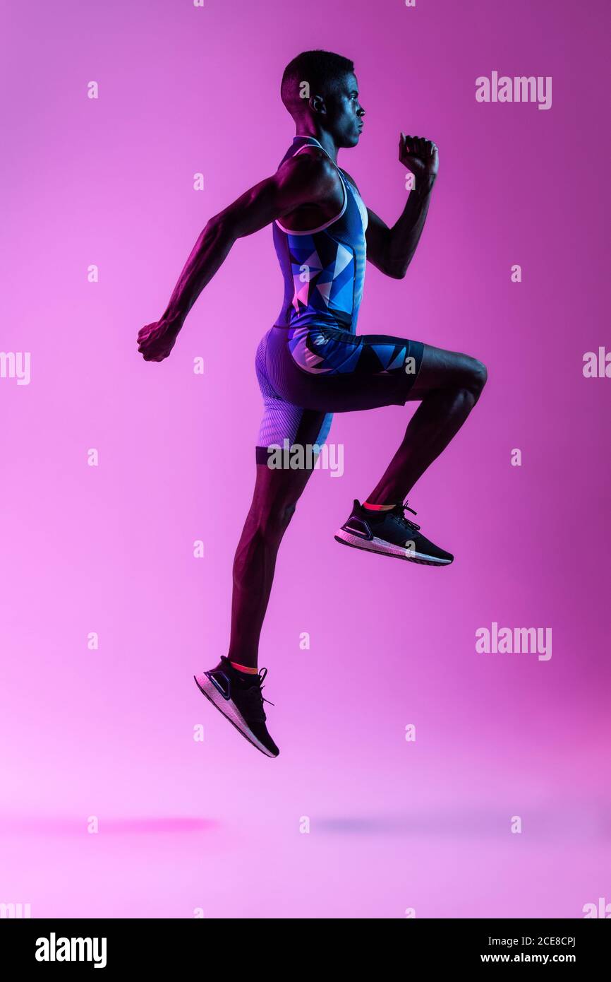 Full body side view of energetic young African American male sprinter ...