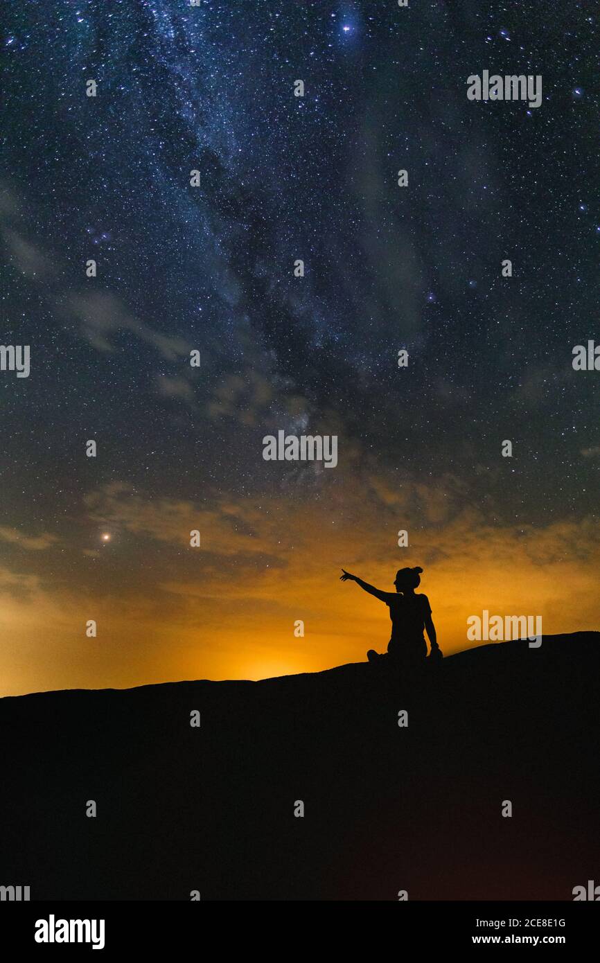 Silhouette of Woman pointing finger the stars while observing the night ...