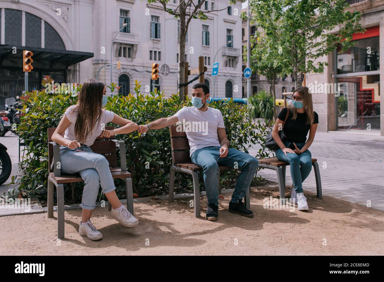 Three friends talking and having fun at the park outdoors wearing face ...