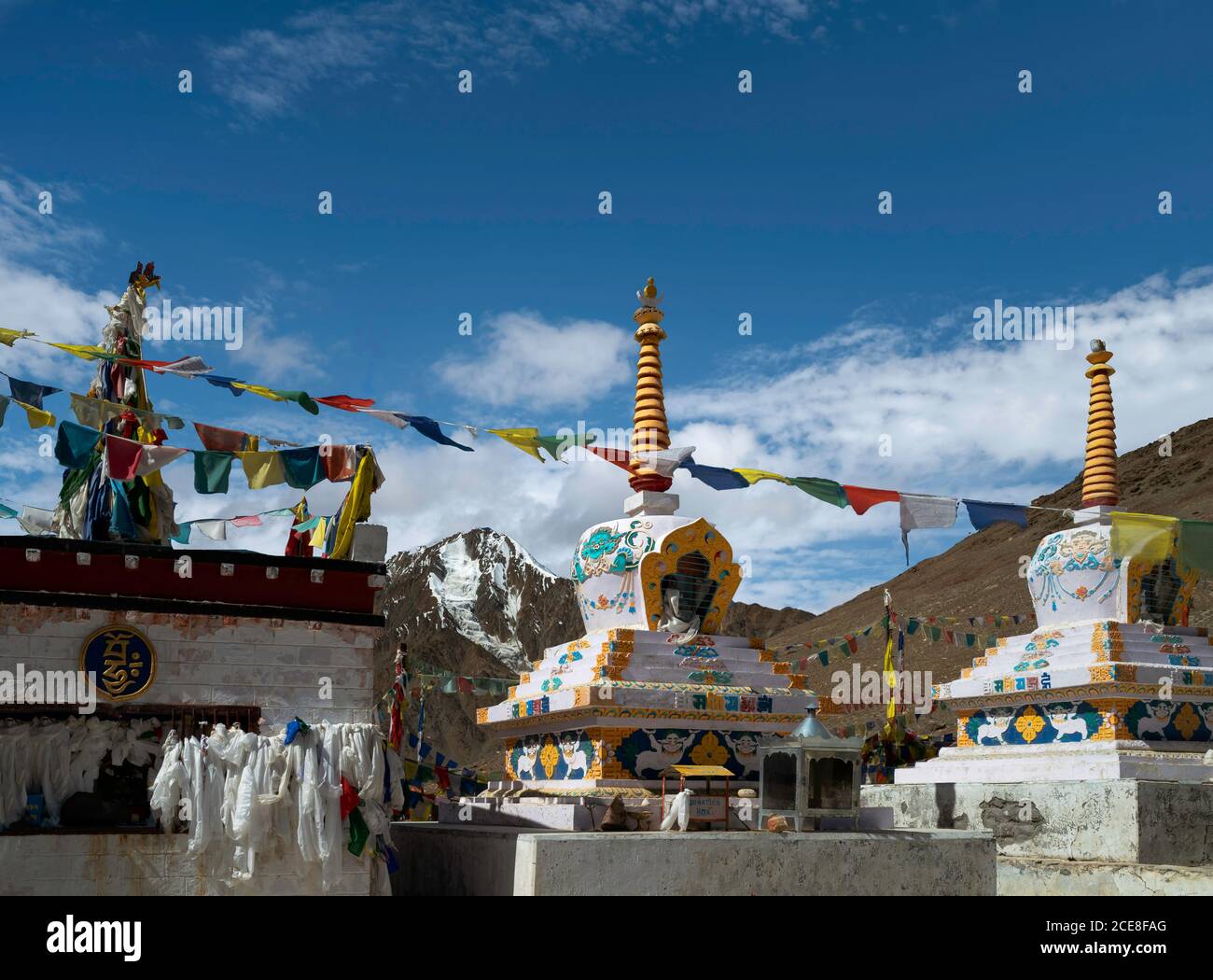 Buddhist stupas with prayer flags overlooking snow-peaked Himalayas ...