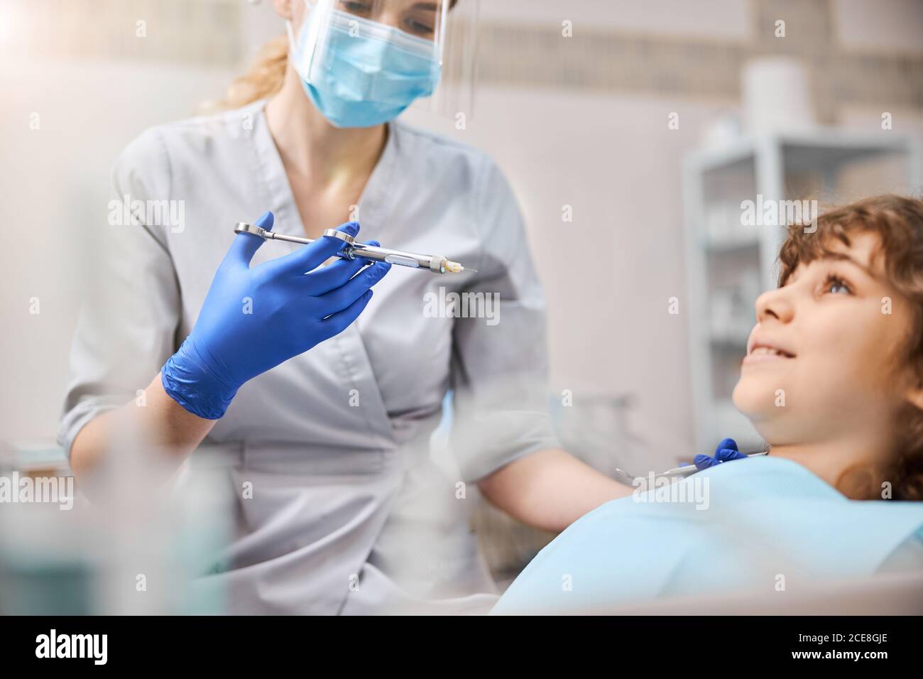 Pediatric dentist giving local anesthesia to boy Stock Photo - Alamy