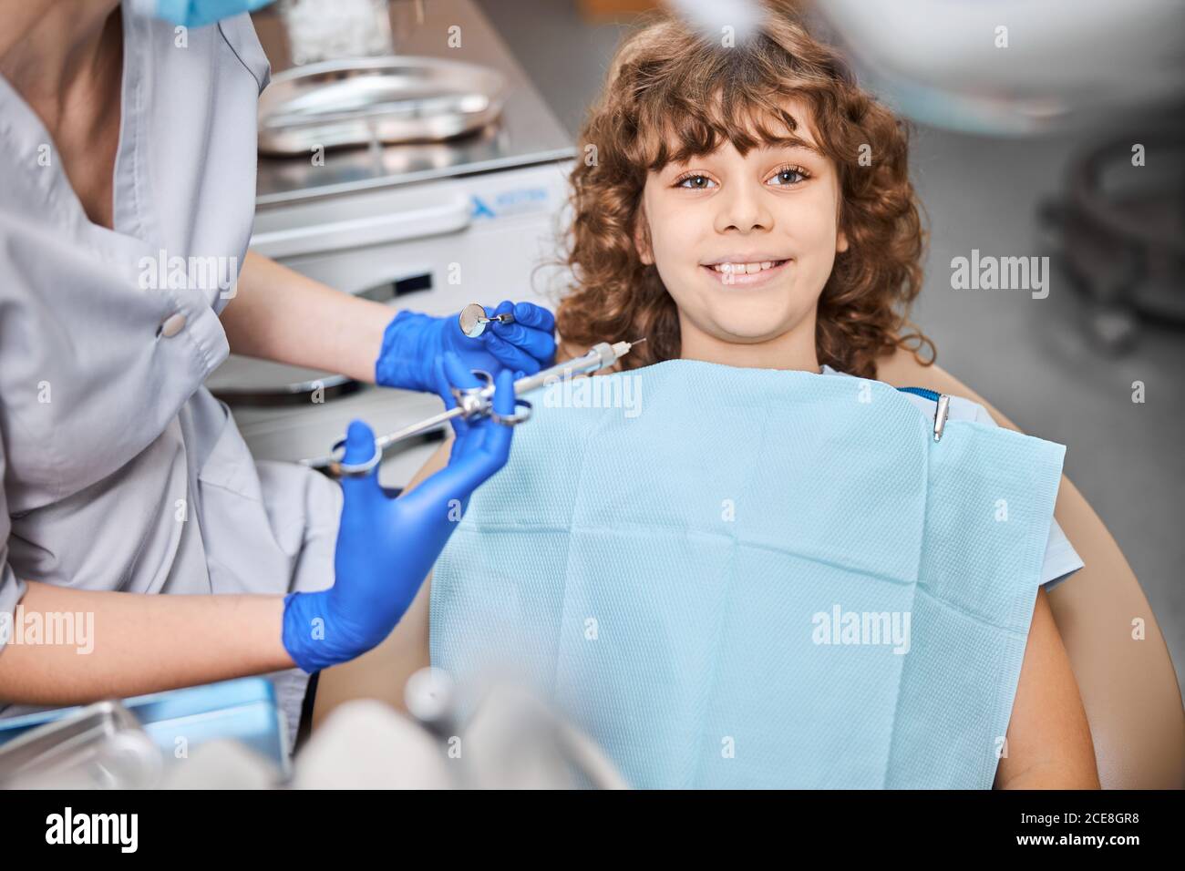 Cute boy sitting in dental chair and smiling after anesthesia Stock ...