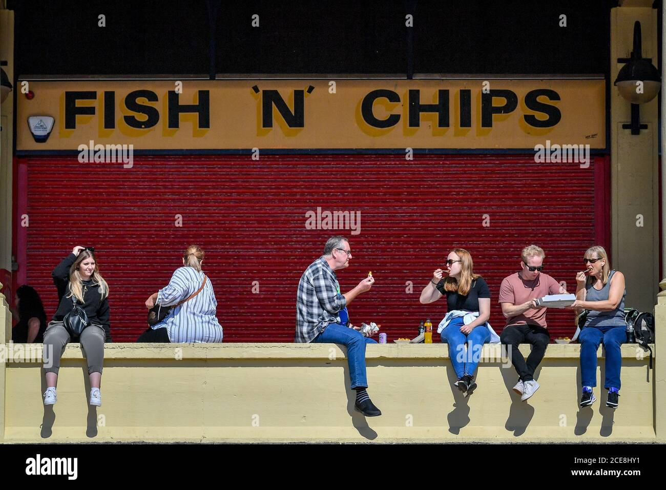 People eat fish and chips at Barry Island, Wales Stock Photo - Alamy