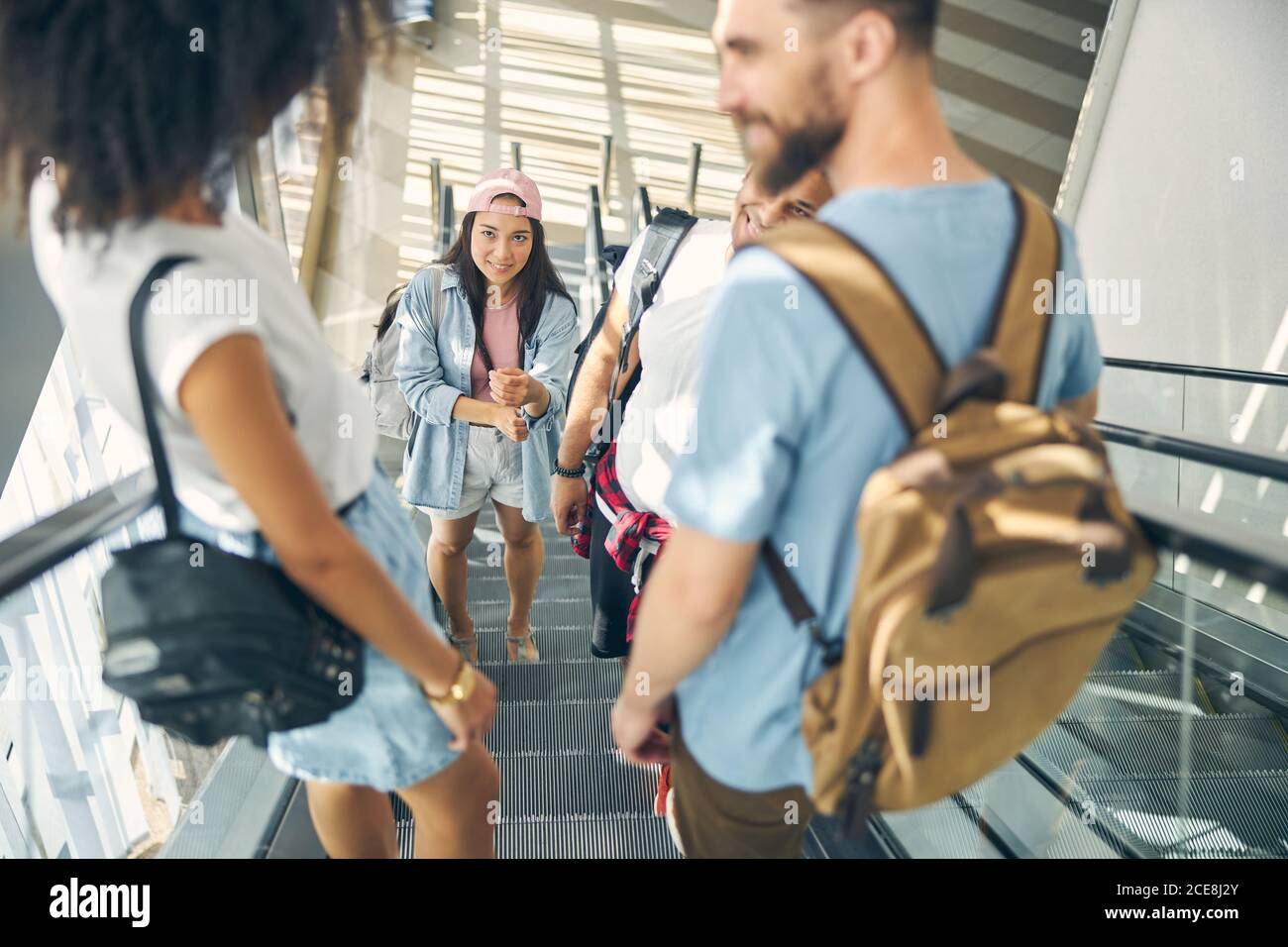 Young happy friends standing on elevator in airport Stock Photo - Alamy