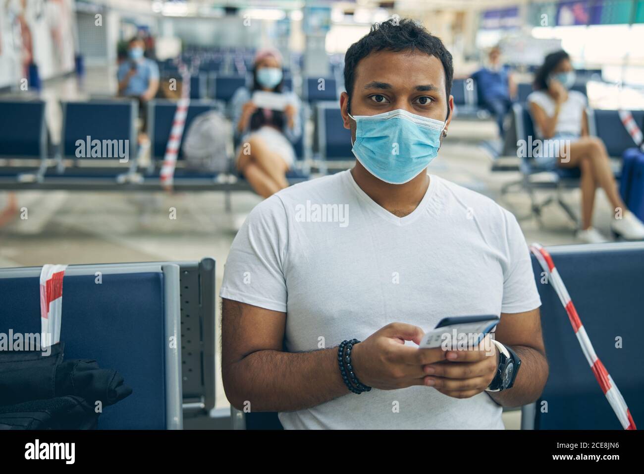 Male using his phone in airport terminal Stock Photo - Alamy