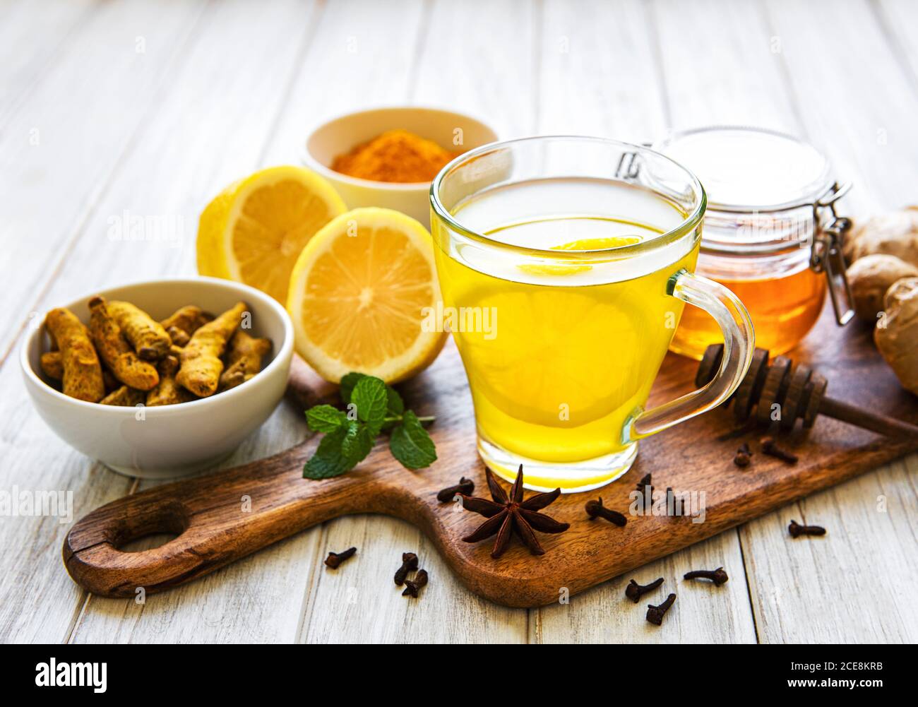 Energy tonic drink with turmeric, ginger, lemon and honey on a white ...