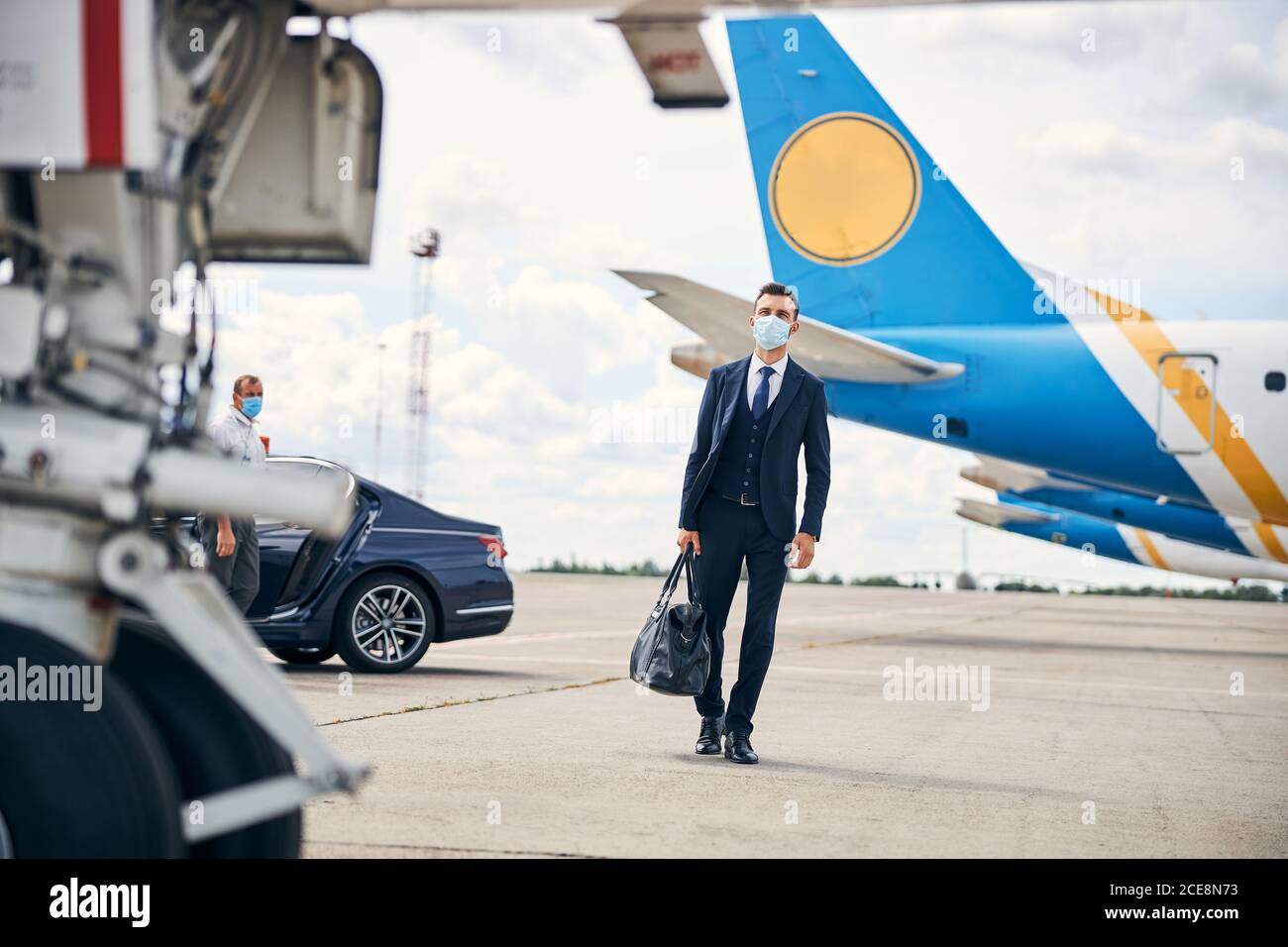 Modern businessman travelling safely with a mask on Stock Photo - Alamy