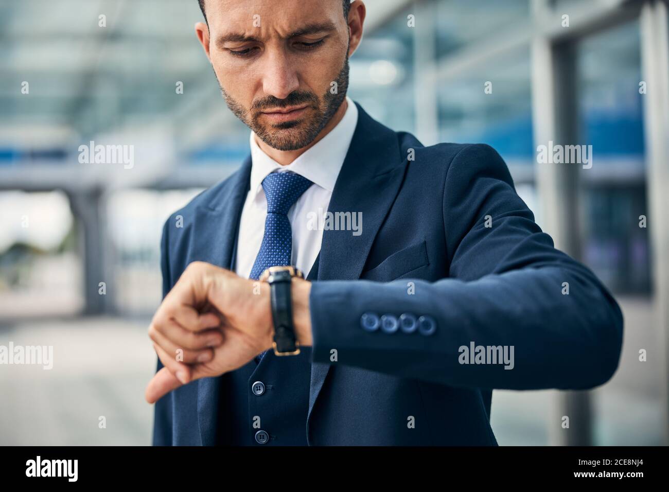 Serious man checking the time on his watch Stock Photo - Alamy