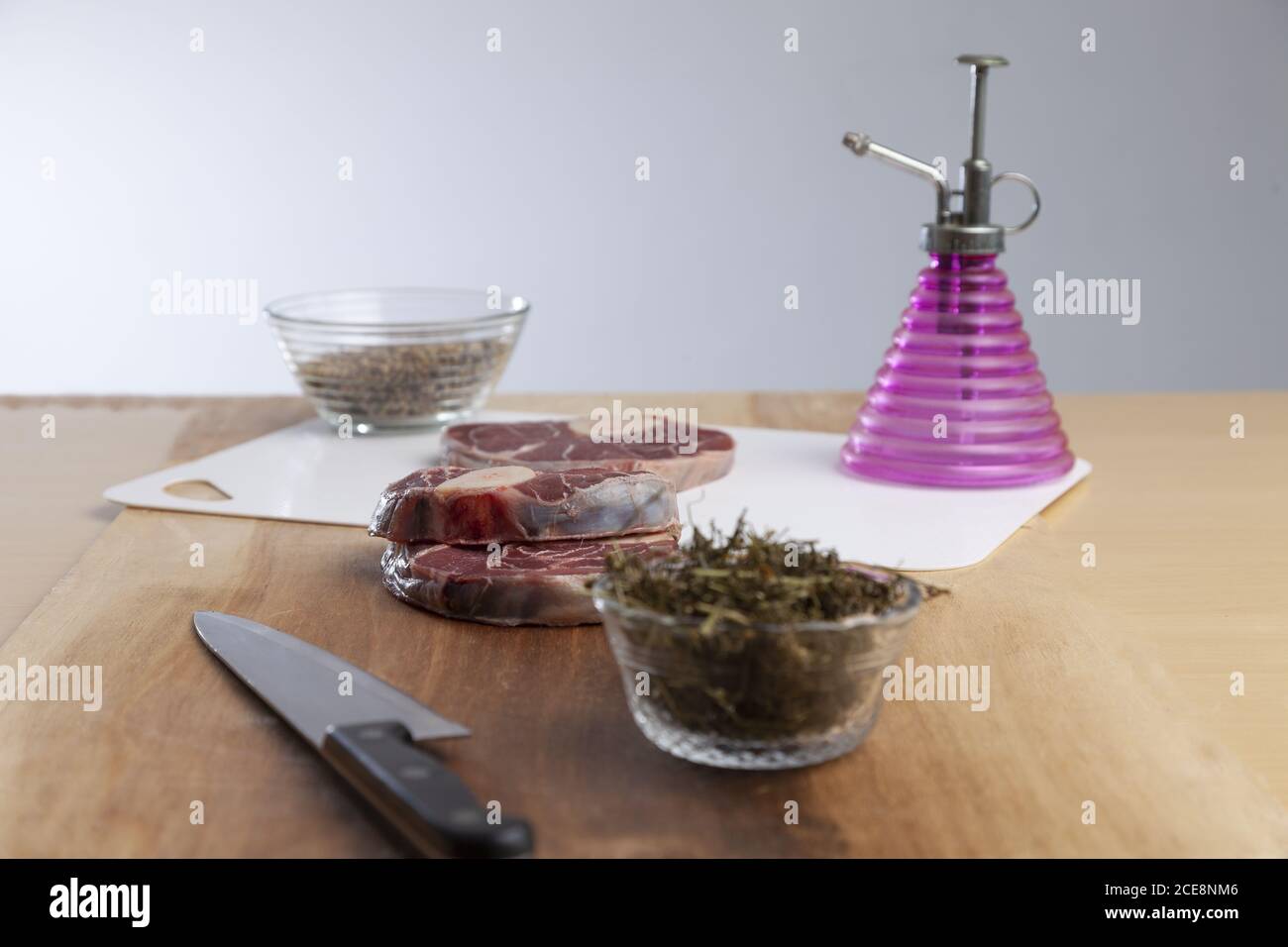 Cutting board with herbs, steak slices, and a spray bottle Stock Photo ...