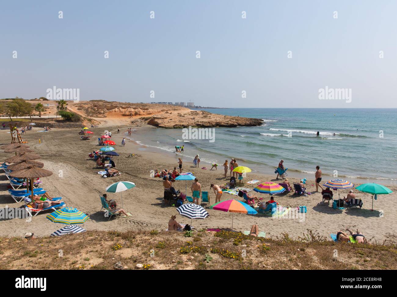 Playa Cala Mosca beach Punta Prima Spain with people on the beach in ...