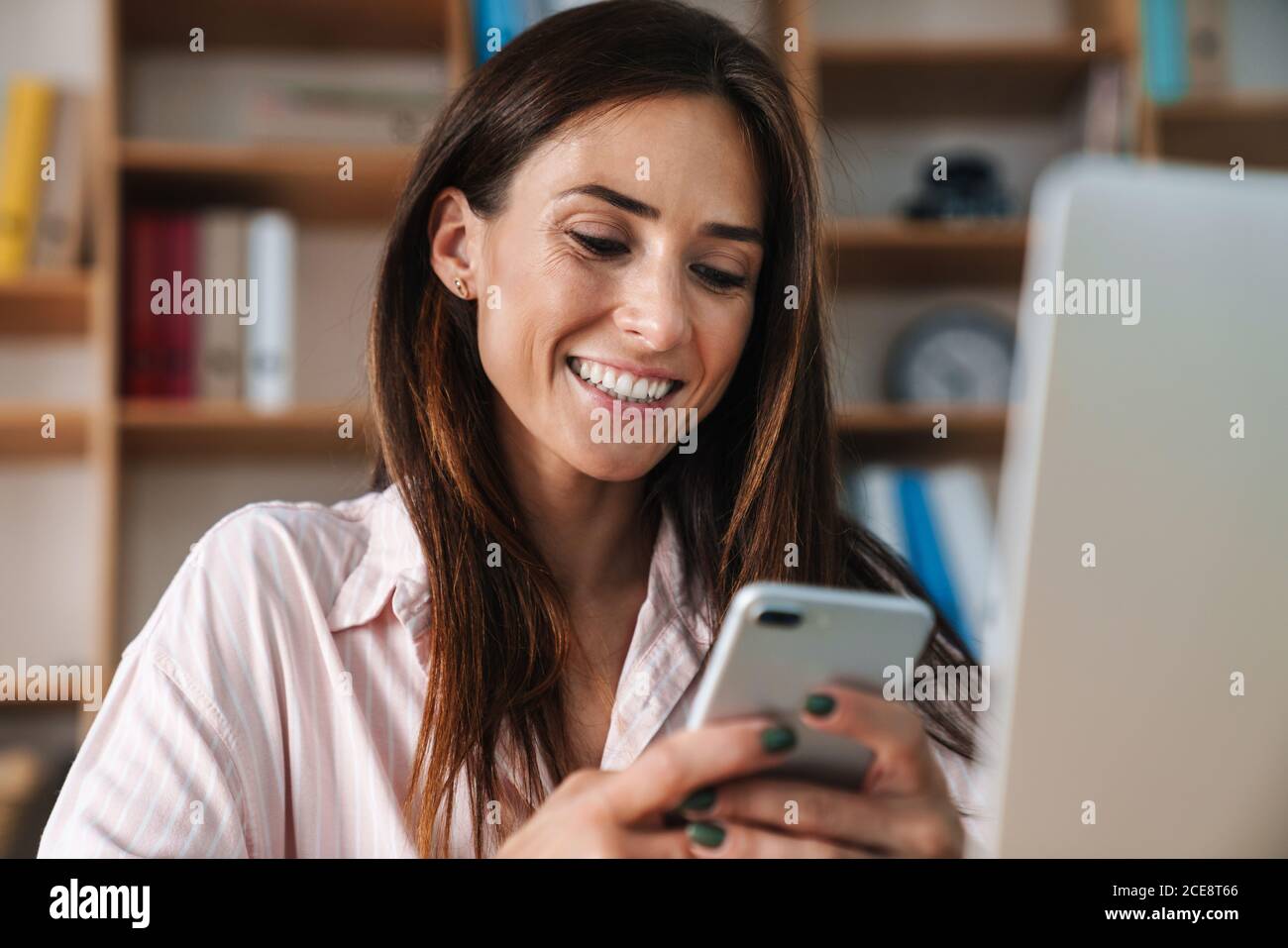 Image of laughing adult businesswoman using mobile phone while working ...