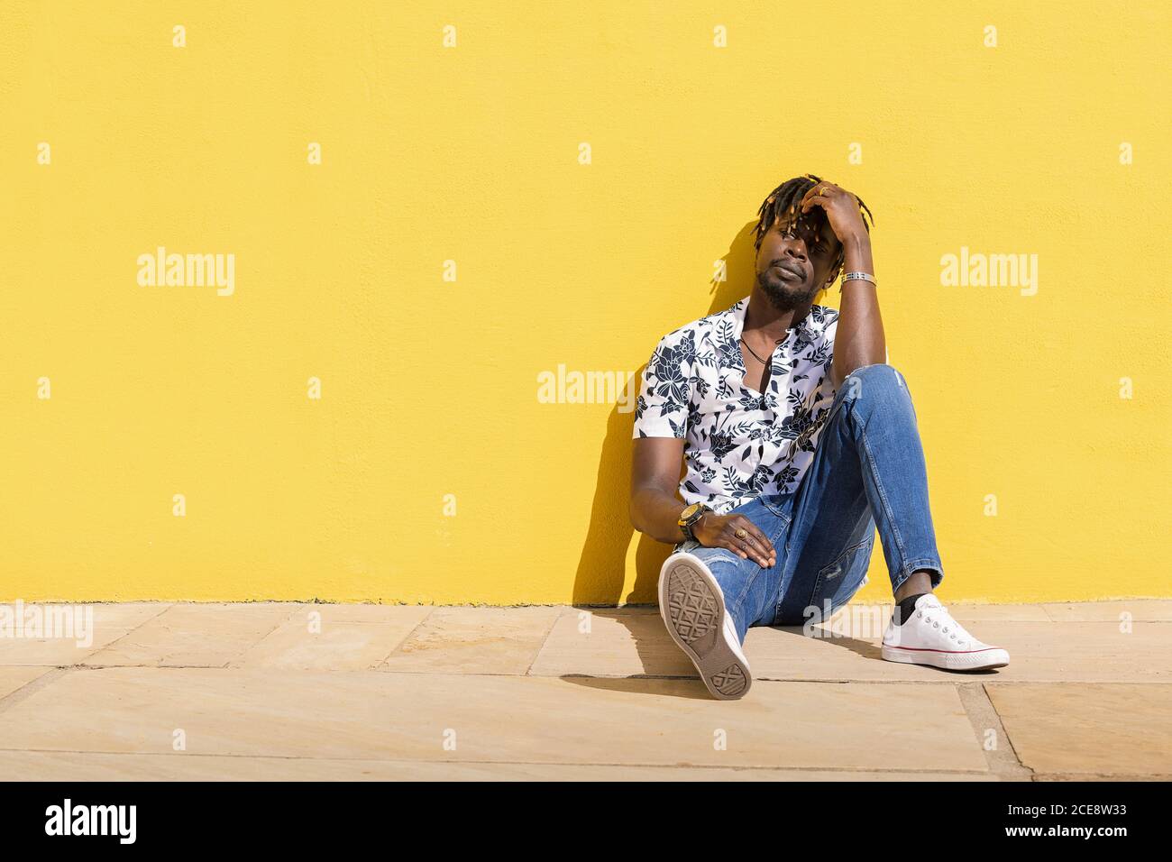 Man sit against wall hi-res stock photography and images - Alamy