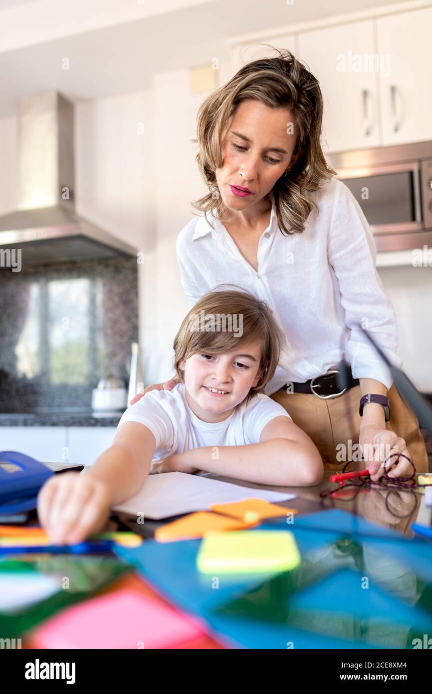 Serious adult Woman in formal outfit revising homework standing near ...