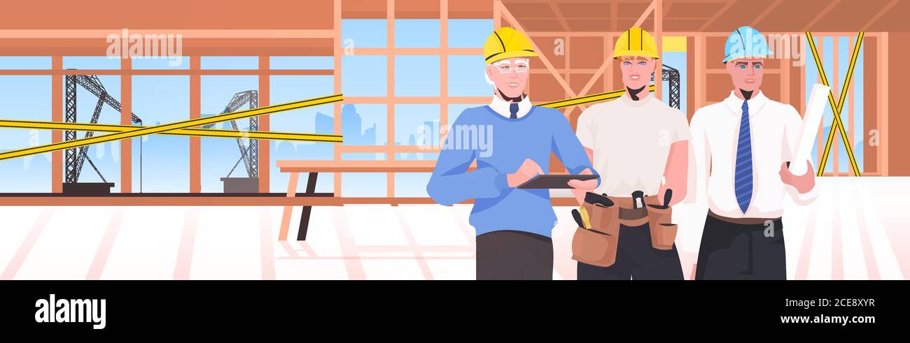 builders team at construction site engineers in helmets discussing ...