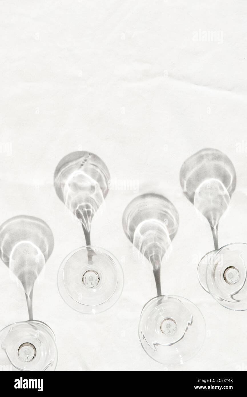 Top view of assorted shiny glasses arranged on white background with ...