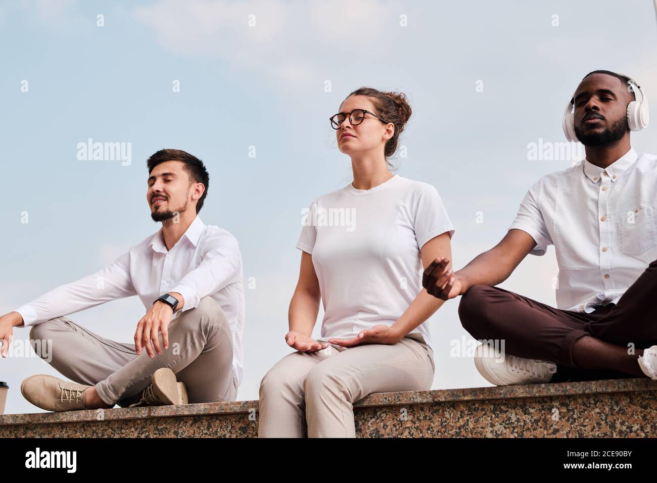 Group of young multi-ethnic people sitting in relaxed position and ...