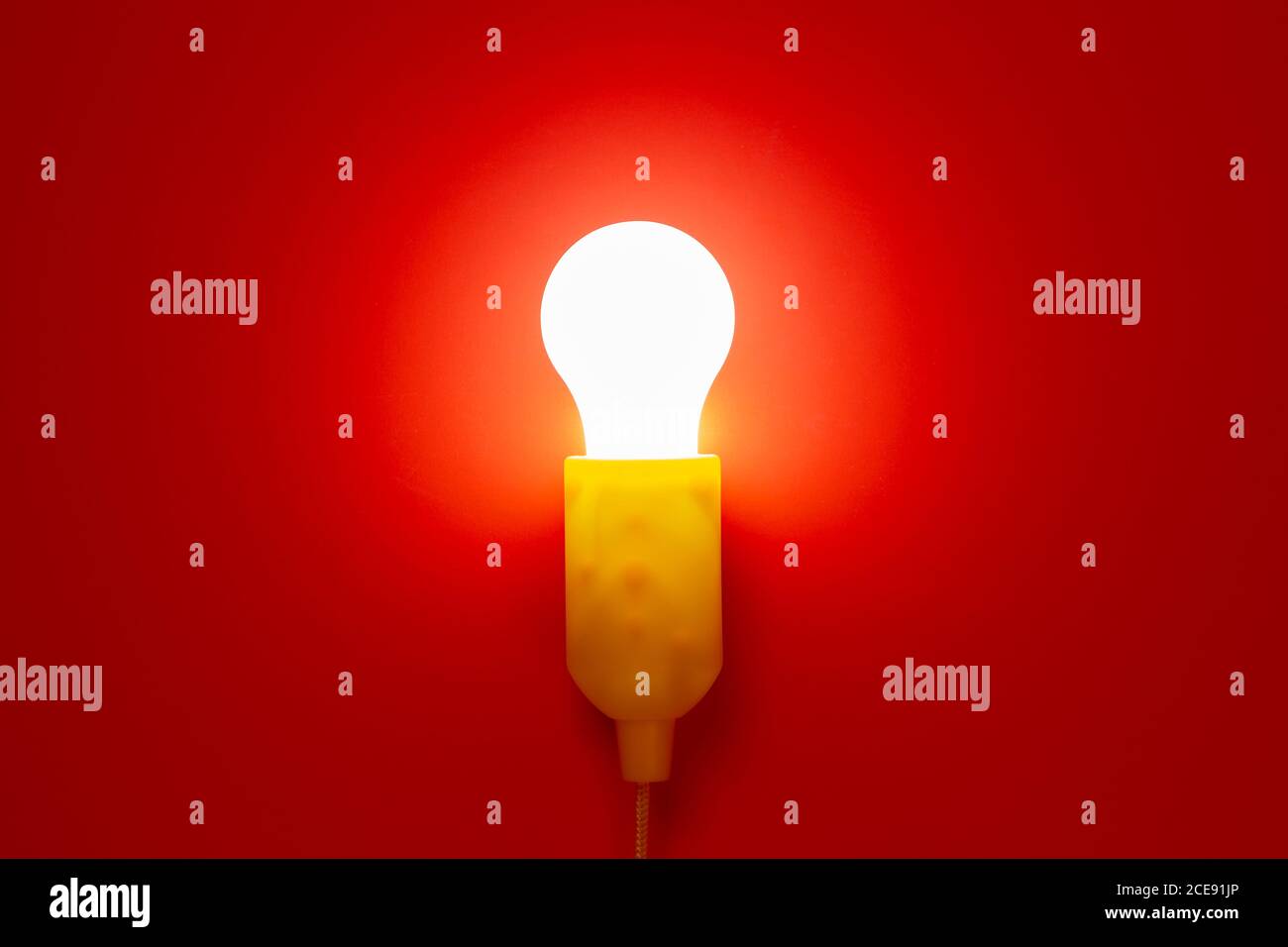 glowing light bulb on red background Stock Photo - Alamy