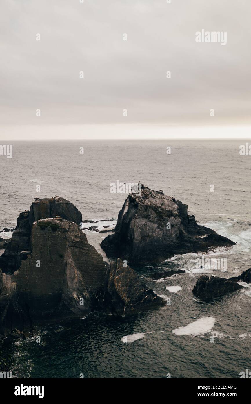 Dark rocky cliffs in ocean Stock Photo - Alamy