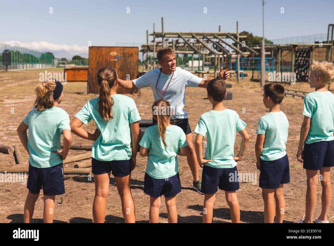 Male fitness coach giving instructions to the kids at a bootcamp Stock ...