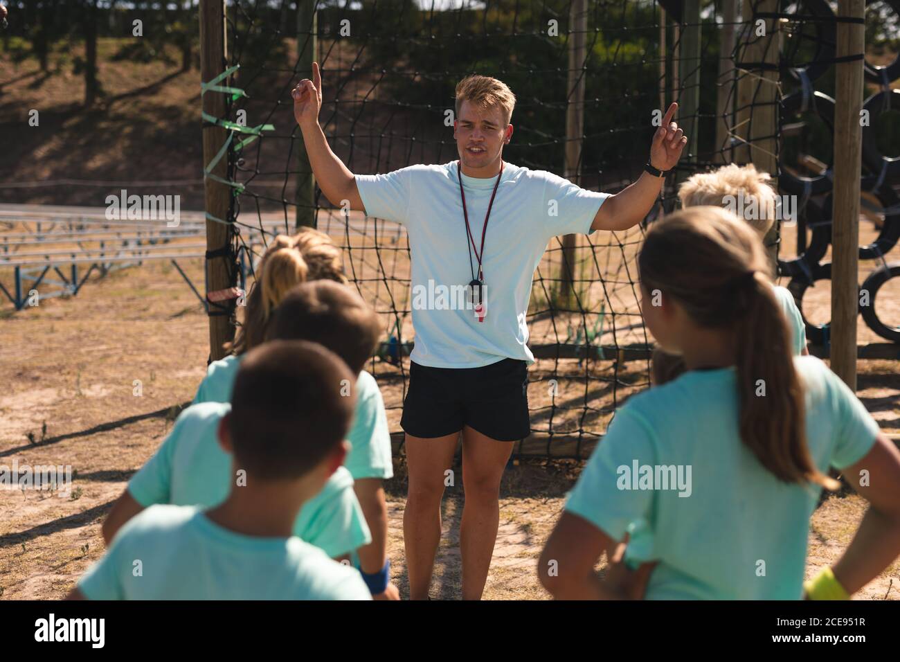 Male fitness coach instructing while kids at a boot camp Stock Photo ...