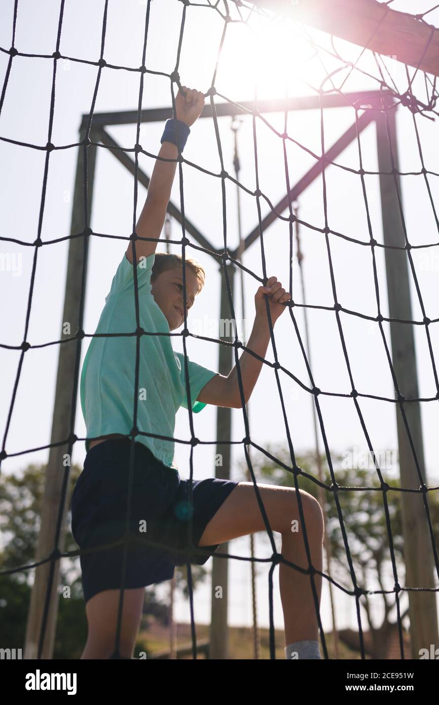 Boy rope climbing during obstacle course at a boot camp Stock Photo - Alamy