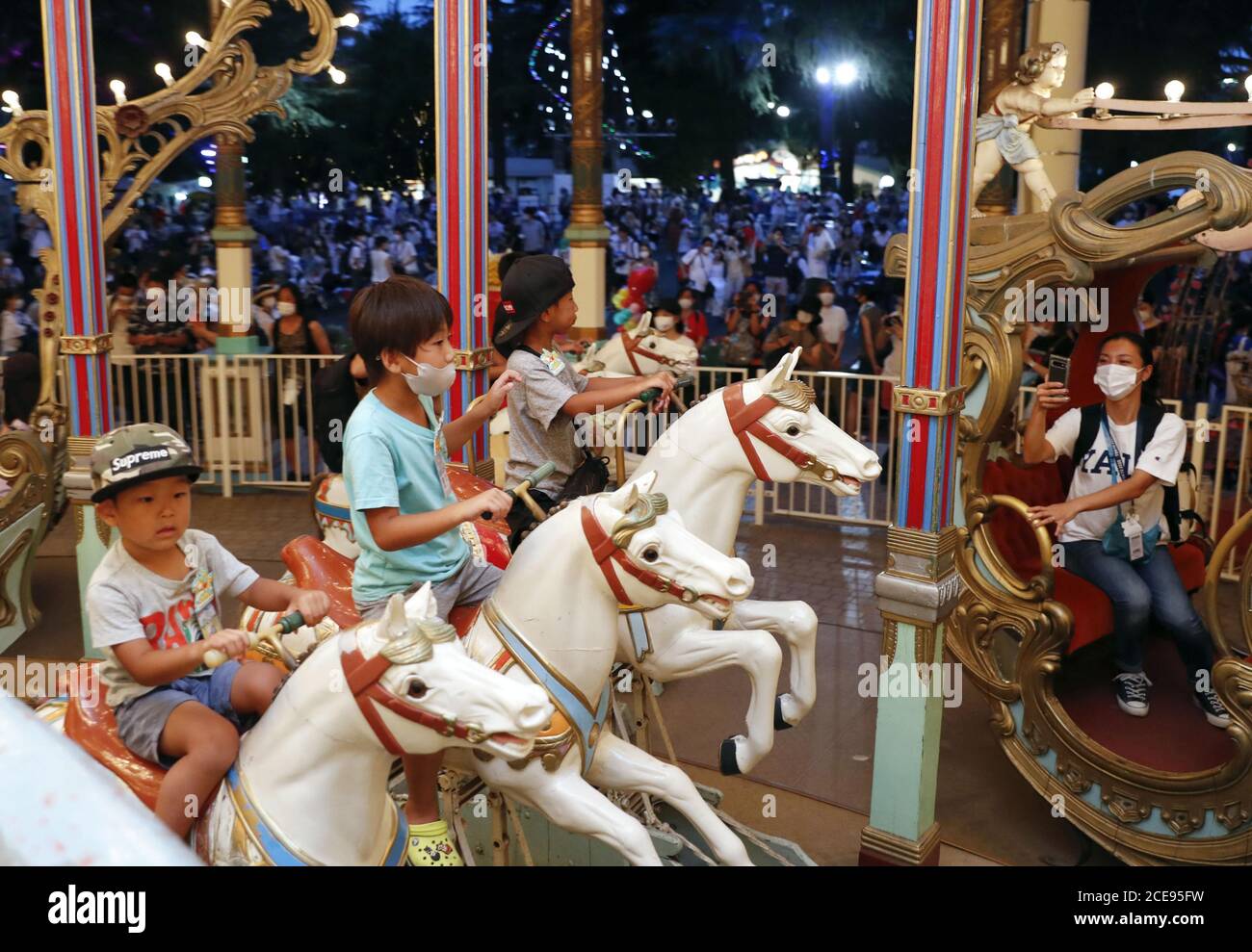 Children ride on the carousel at Toshimaen amusement park in Tokyo on ...