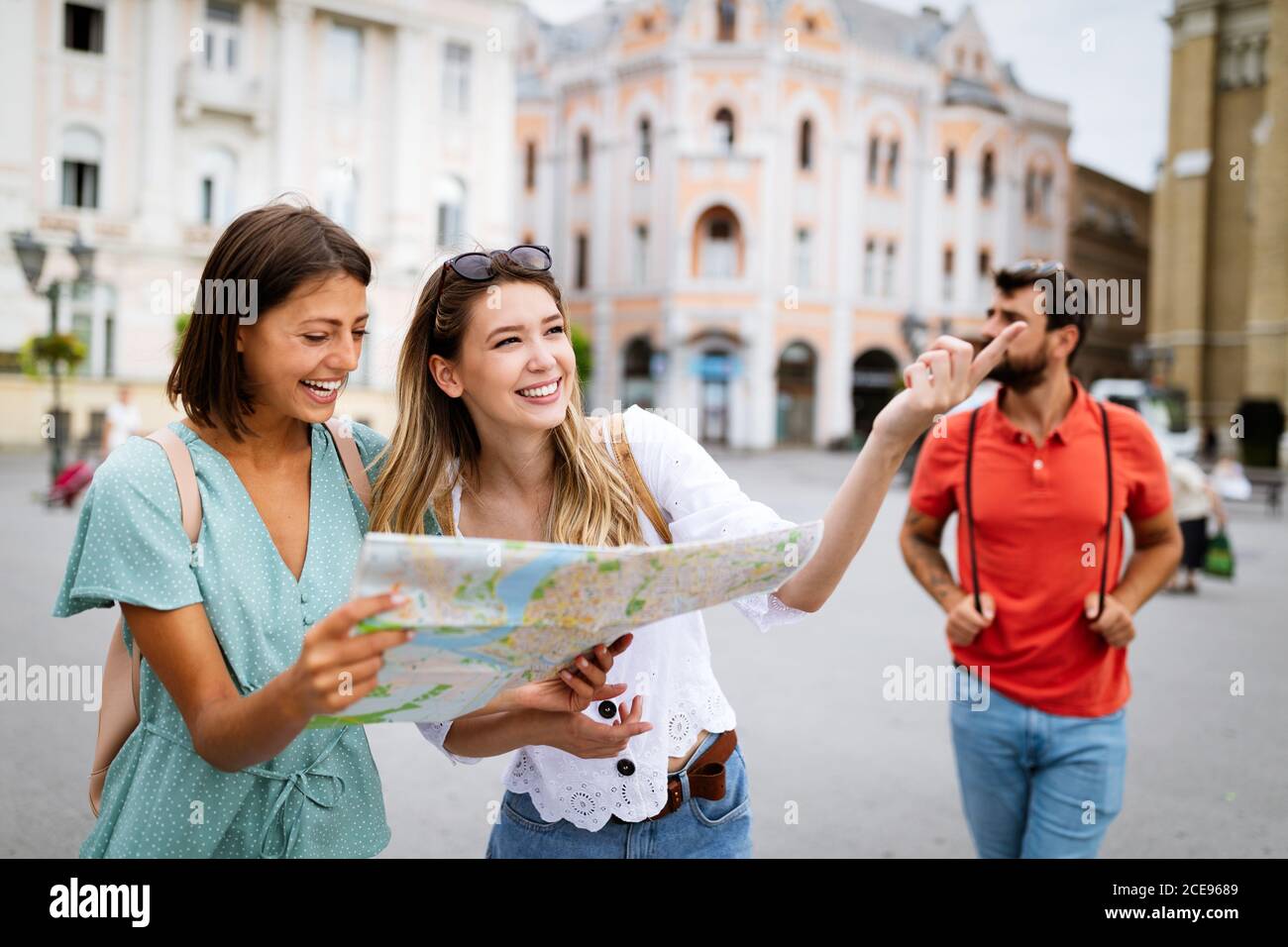 Happy traveling tourists sightseeing with map and having fun Stock ...
