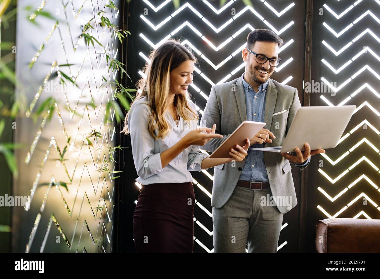 Cheerful coworkers in office working and brainstorming together Stock ...