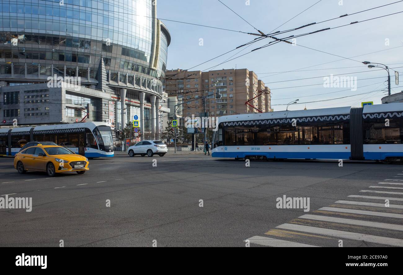 March 18, 2019, Moscow, Russia. Taxi service car and tram on a busy ...