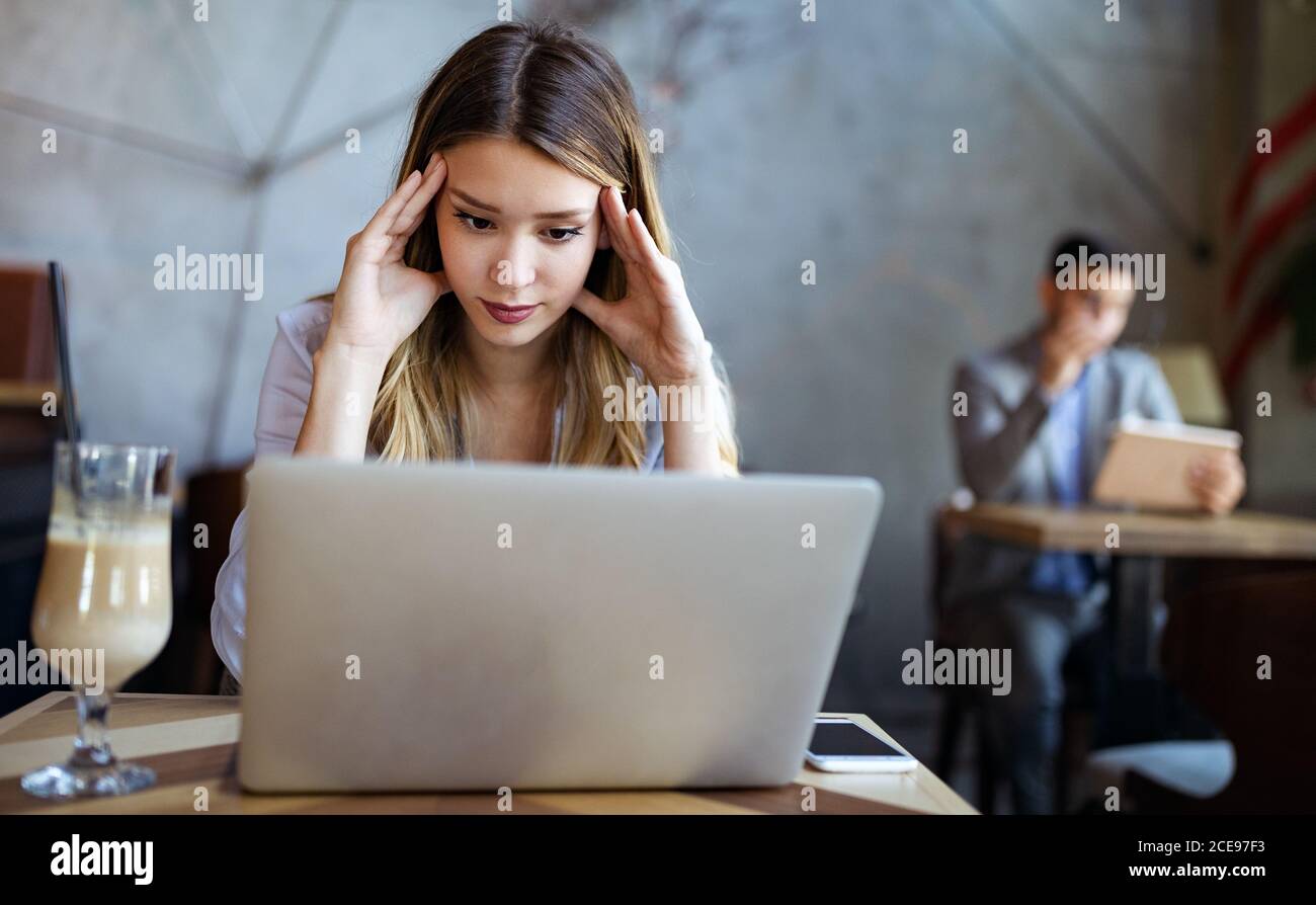Portrait of tired young business woman with laptop Stock Photo - Alamy